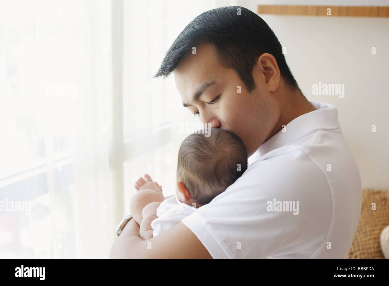 Father carrying baby daughter Stock Photo - Alamy