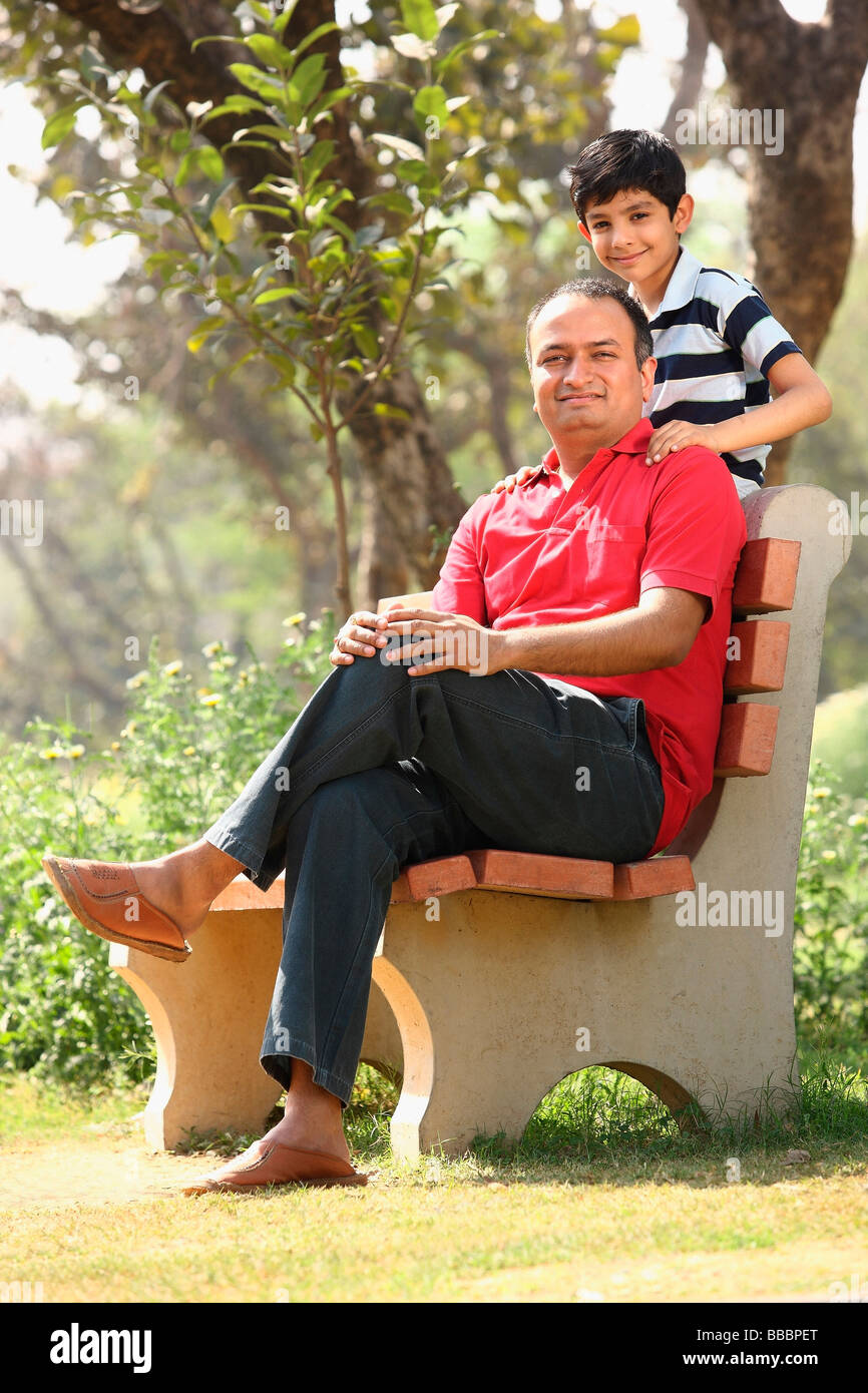 Father on bench, son standing Stock Photo - Alamy