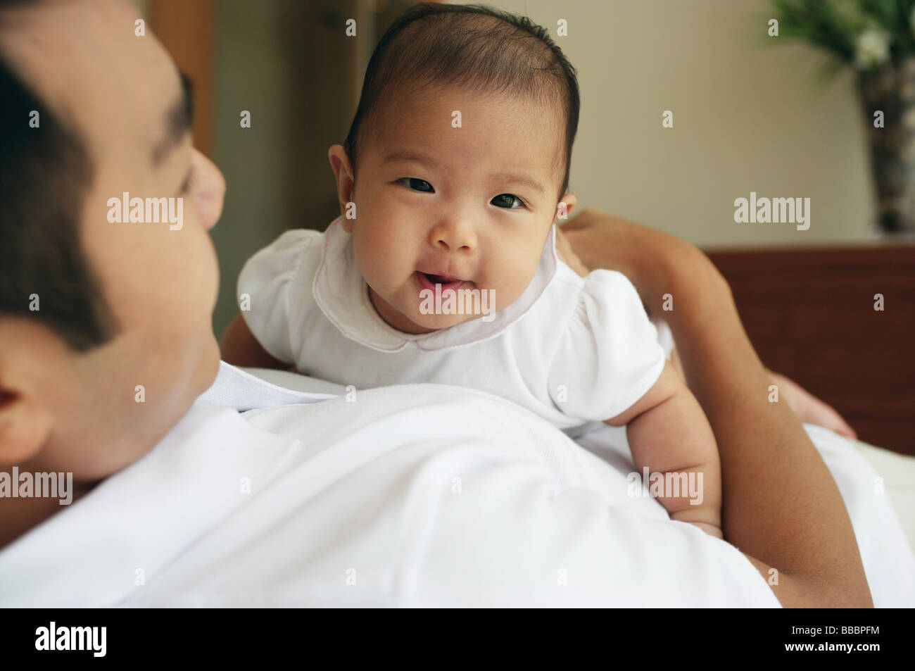 Father carrying baby daughter, high angle view Stock Photo - Alamy
