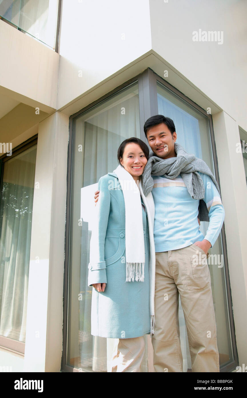 Couple standing outside house, smiling at camera Stock Photo - Alamy