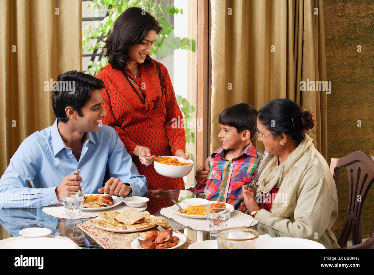 woman serves dinner to her family Stock Photo - Alamy