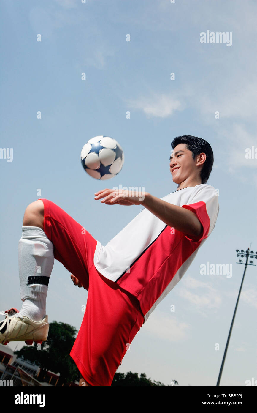 Young man playing with soccer ball, keeping ball up Stock Photo - Alamy