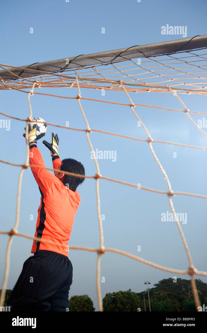 Soccer goalie reaching for ball Stock Photo - Alamy