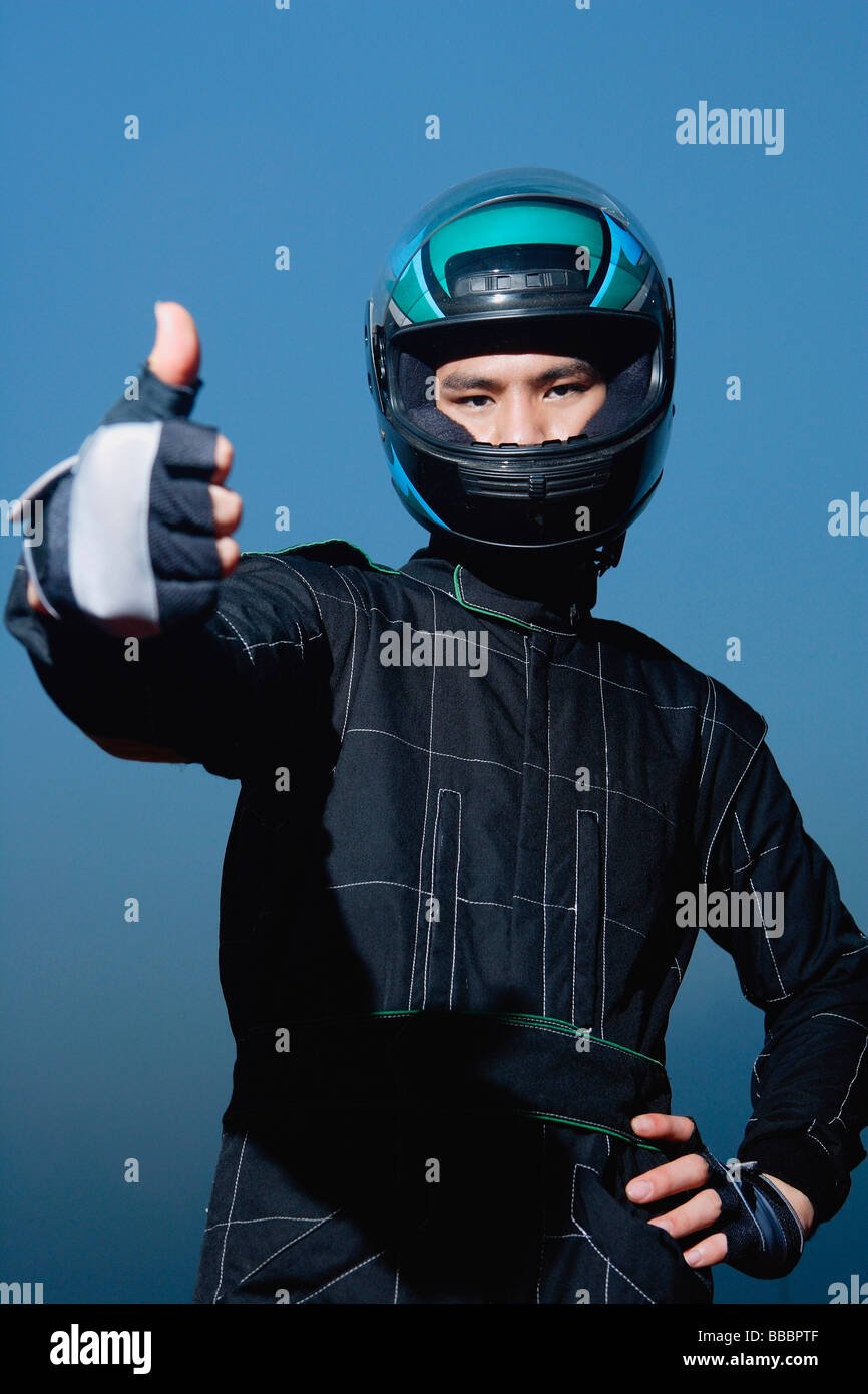 Race car driver in protective sportswear, making thumbs up sign Stock ...