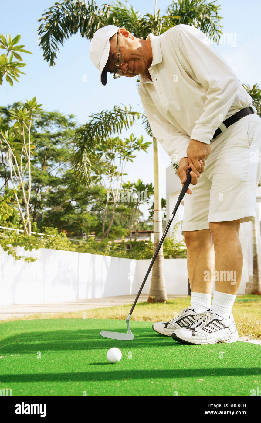 Mature man holding golf club Stock Photo - Alamy