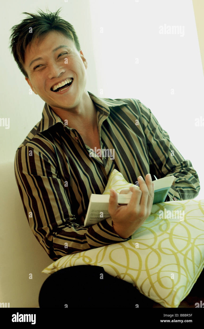 Man holding a book, looking at camera, smiling Stock Photo - Alamy