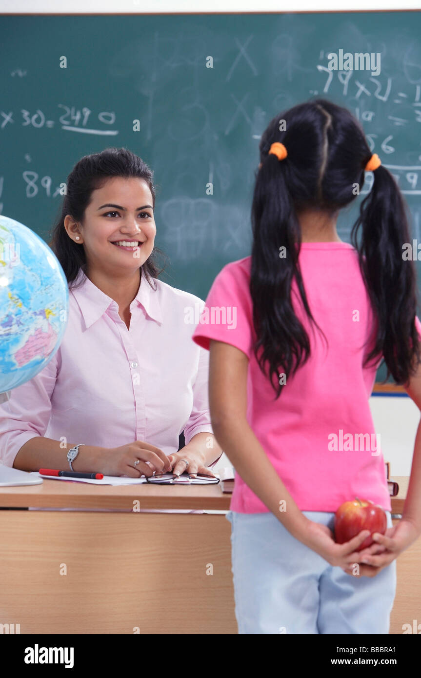 student holding apple for teacher Stock Photo - Alamy
