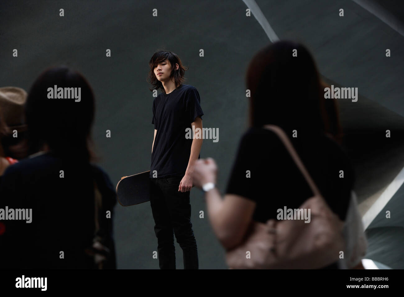 youth holding skateboard, in crowd Stock Photo - Alamy