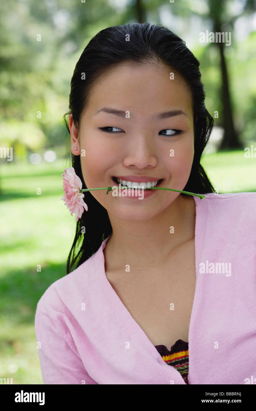 Young woman biting flower stalk hi-res stock photography and images - Alamy