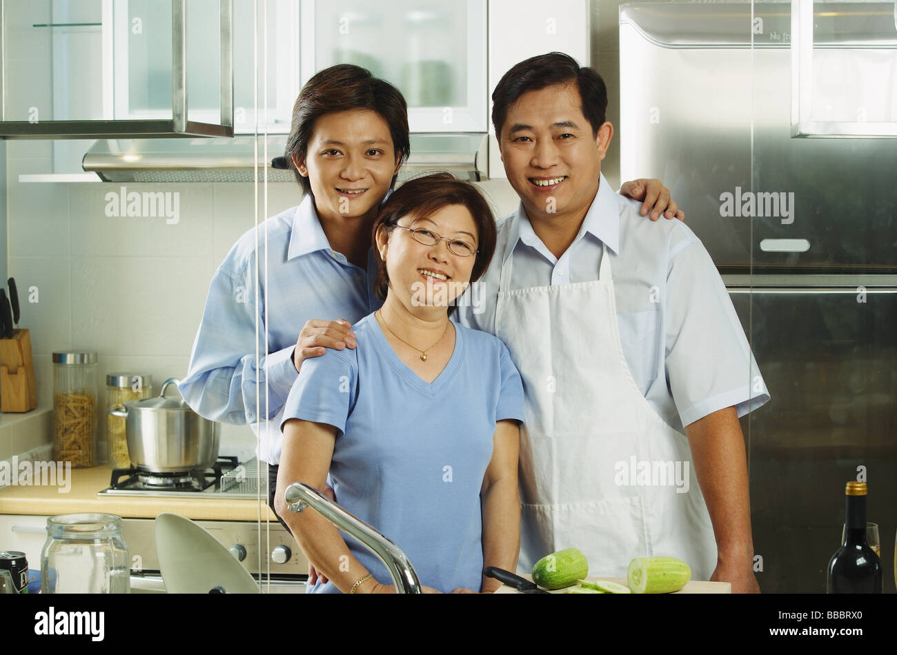 Family with adult offspring, standing in kitchen Stock Photo - Alamy