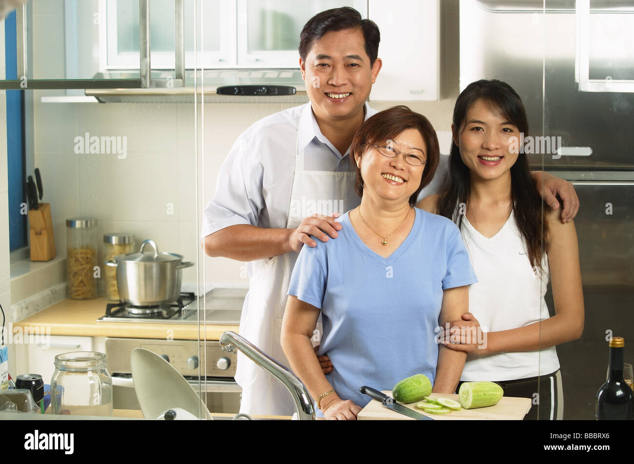 Family with adult offspring, standing in kitchen Stock Photo - Alamy