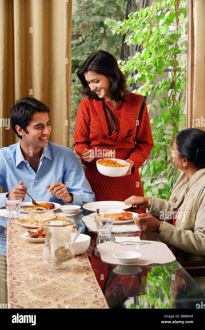 woman serves dinner to man and older woman (vertical Stock Photo - Alamy
