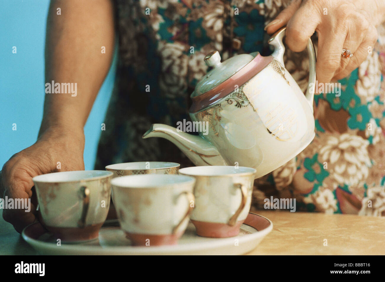 Elderly person pouring tea into cups Stock Photo - Alamy