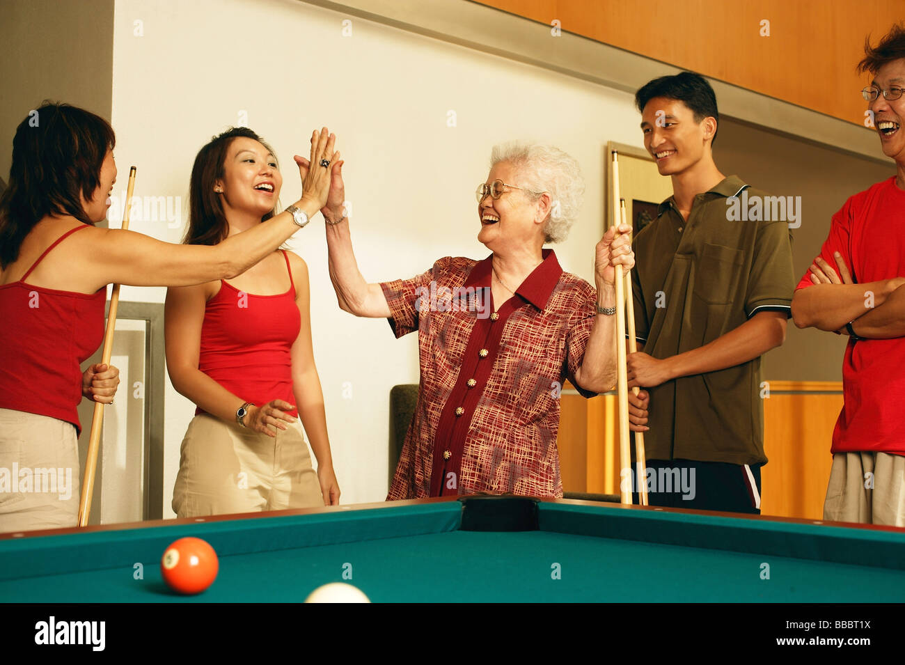 Three generation family around pool table Stock Photo - Alamy