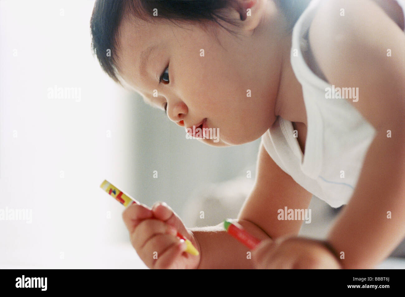 Young boy holding crayons Stock Photo - Alamy