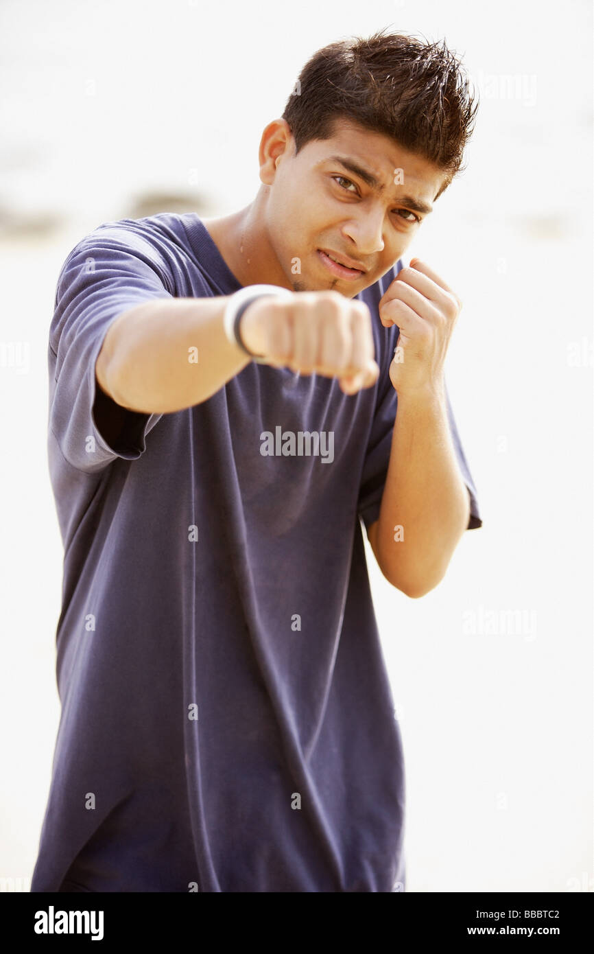 Young man throwing a punch, looking at camera Stock Photo - Alamy
