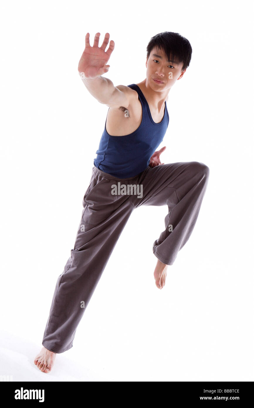 Young man practicing kong fu, balancing on one leg Stock Photo - Alamy