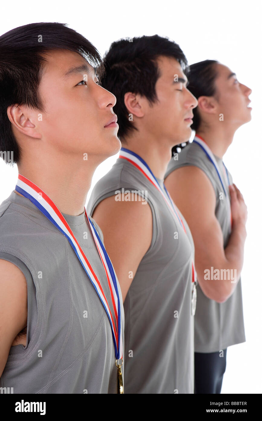Three athletes in a row with medals around their necks Stock Photo - Alamy