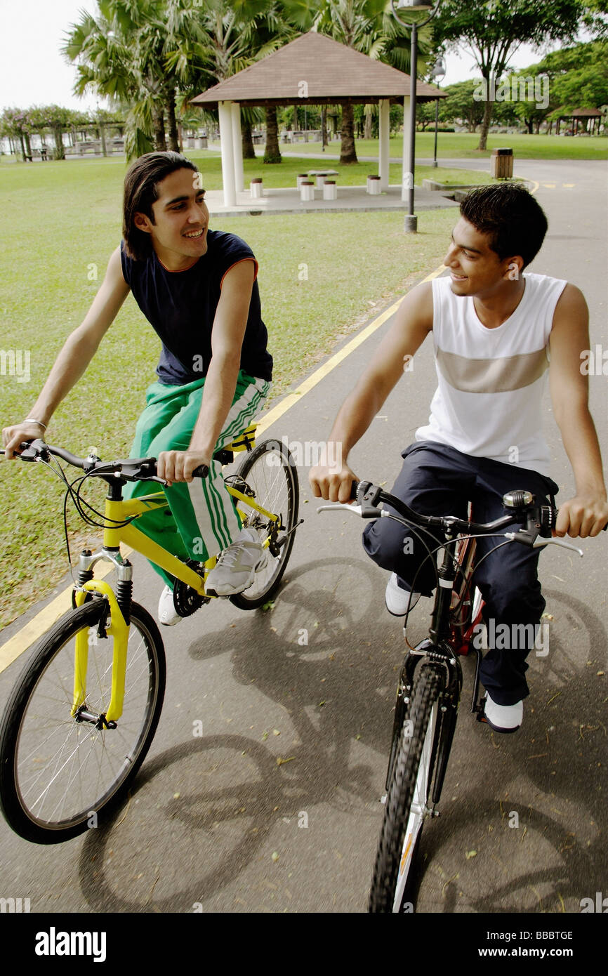 Two young men cycling side by side Stock Photo - Alamy