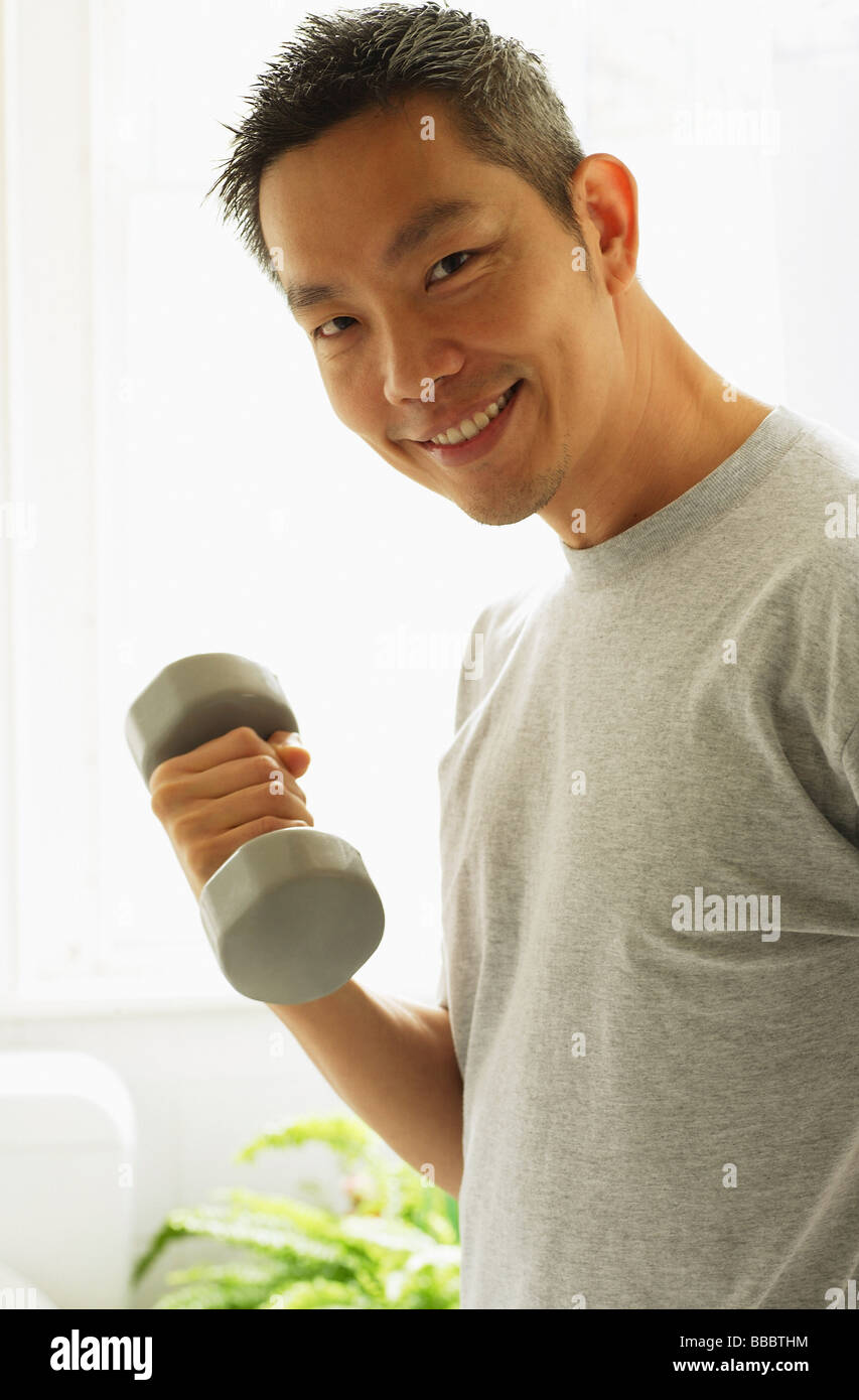 Man lifting weights, looking at camera Stock Photo - Alamy