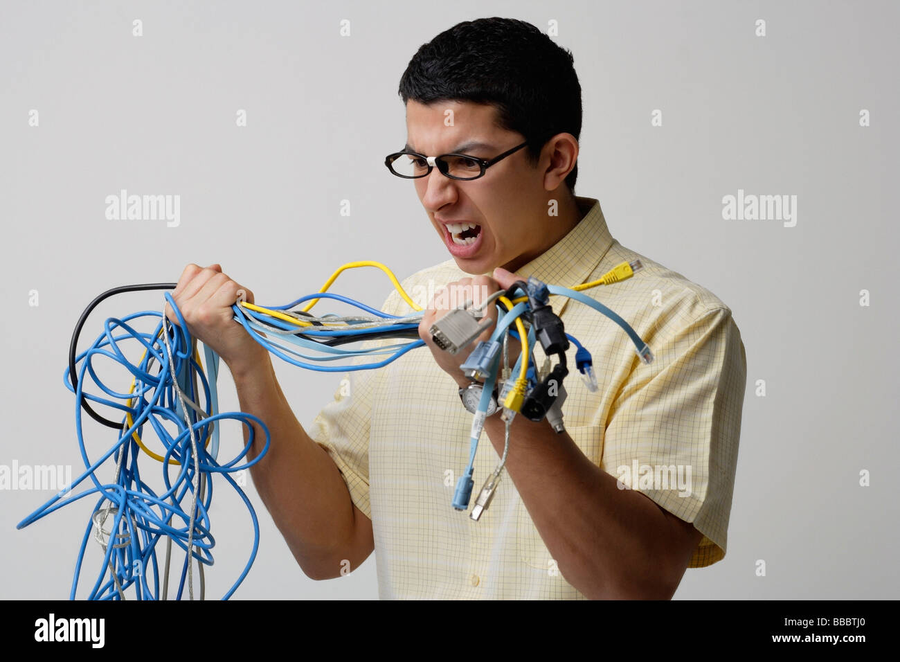 Frustrated man with tangled wires Stock Photo - Alamy