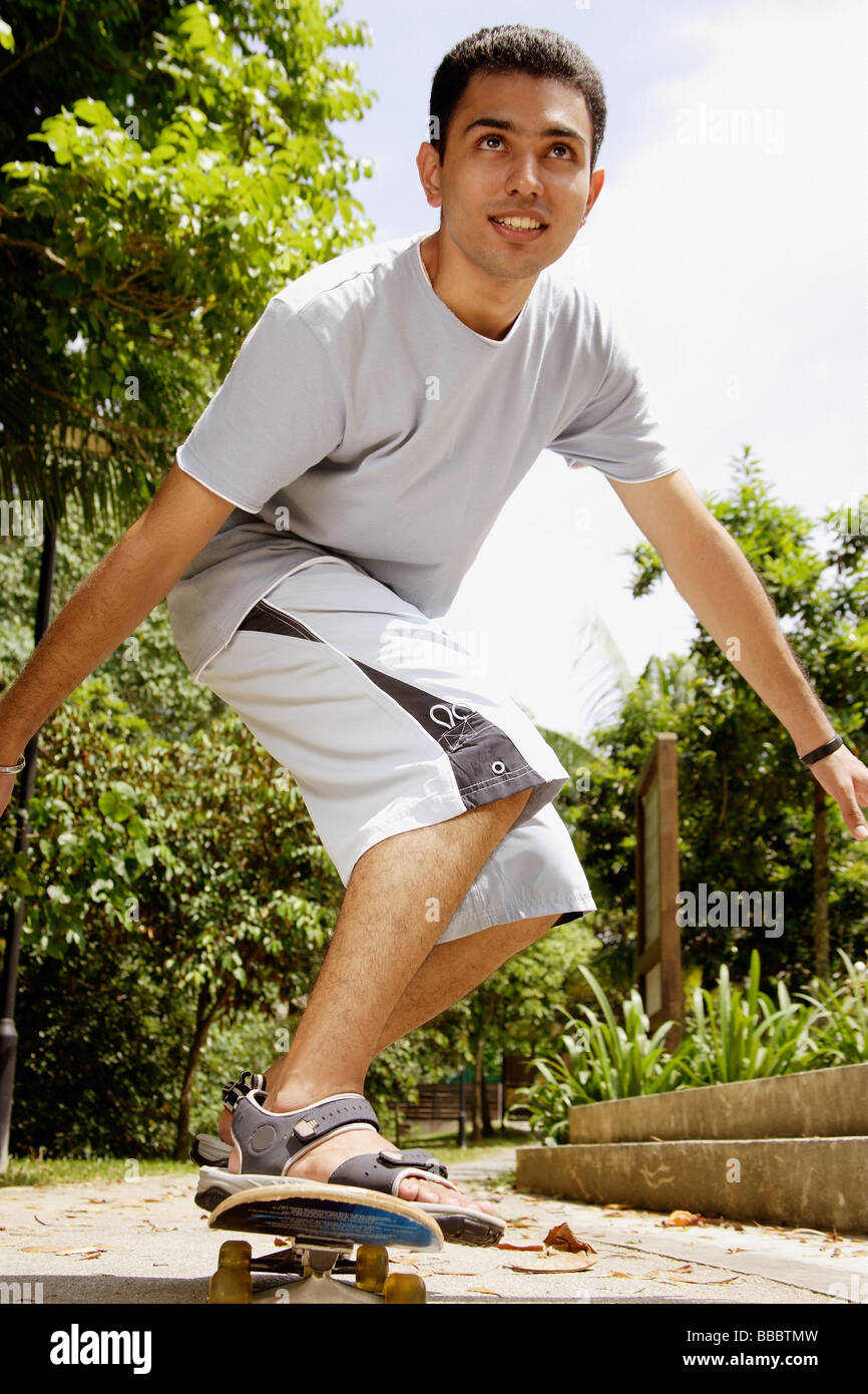 Man balancing on skateboard, looking away Stock Photo - Alamy