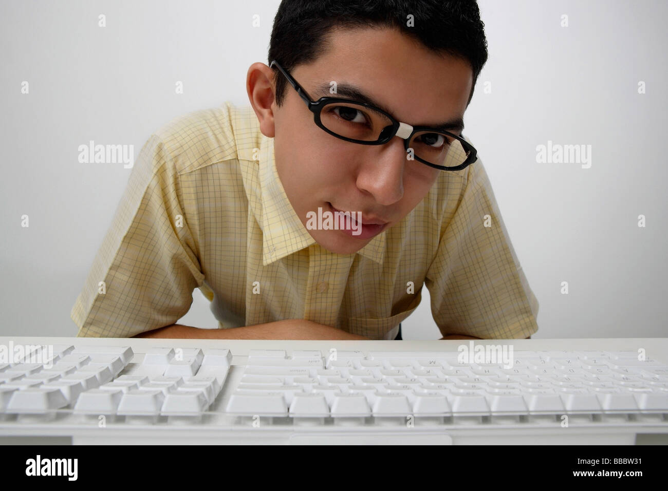 Nerd looking over keyboard Stock Photo - Alamy