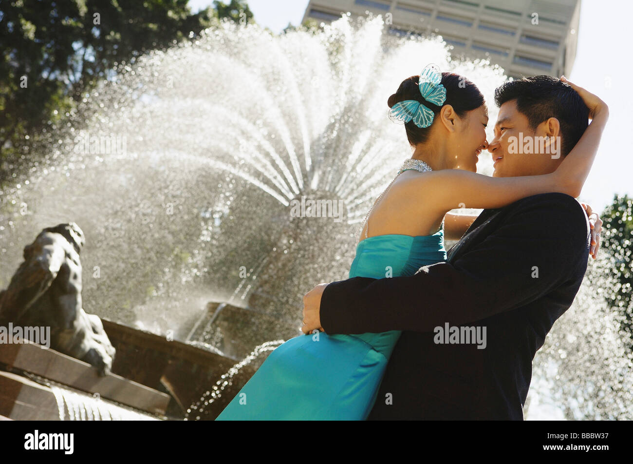 Couple hugging, water fountain behind them Stock Photo - Alamy