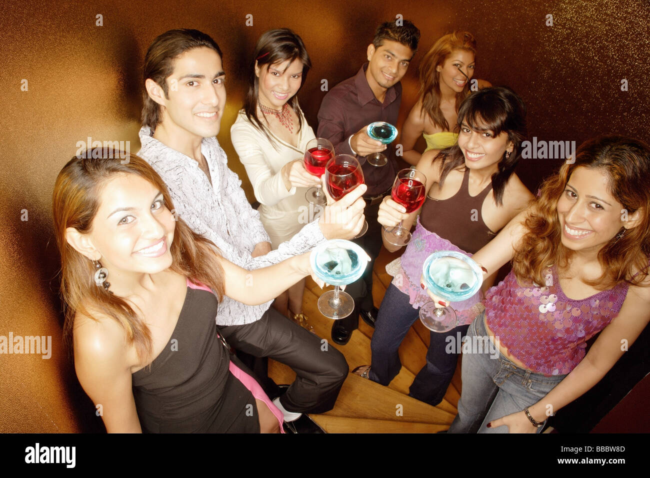 Young adults raising drinks to camera Stock Photo - Alamy