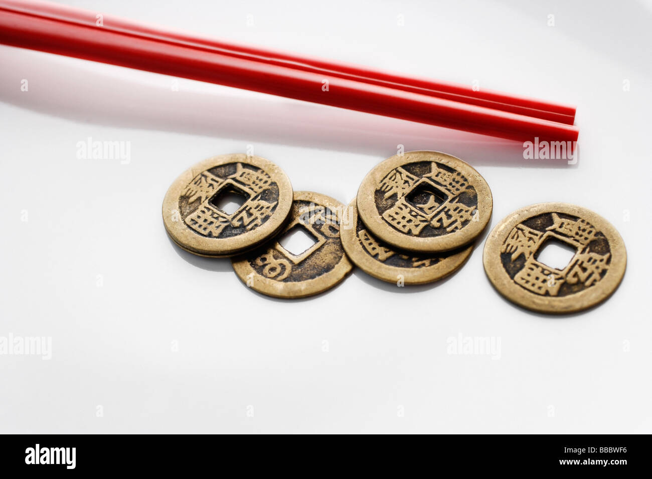 Chinese coins with red chopsticks Stock Photo - Alamy