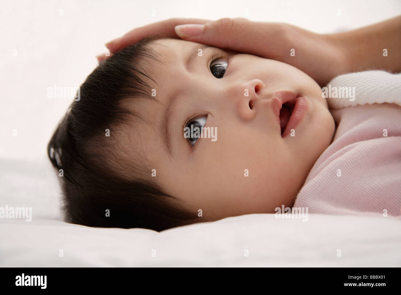 Hand caressing baby girl face hi-res stock photography and images - Alamy