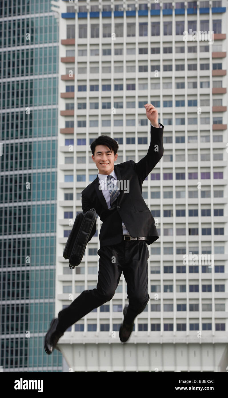 Excited businessman jumping holding hi-res stock photography and images ...