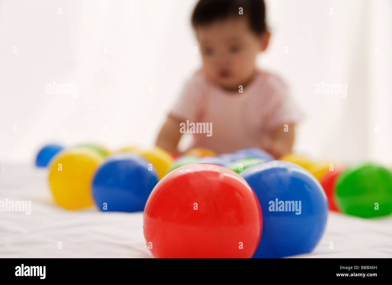 baby girl playing with balls Stock Photo - Alamy
