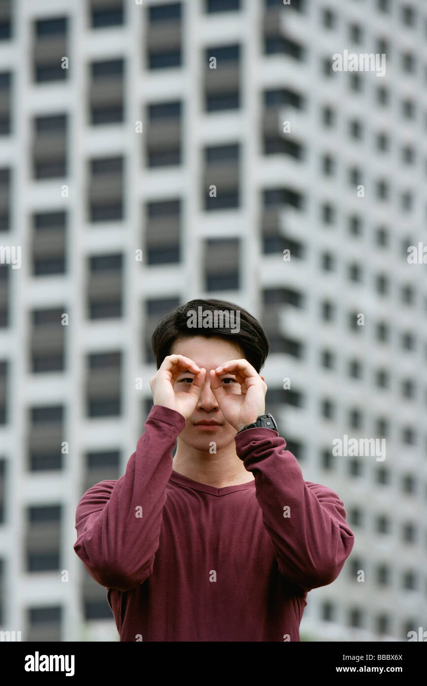 Man looking at camera, looking through hands Stock Photo - Alamy