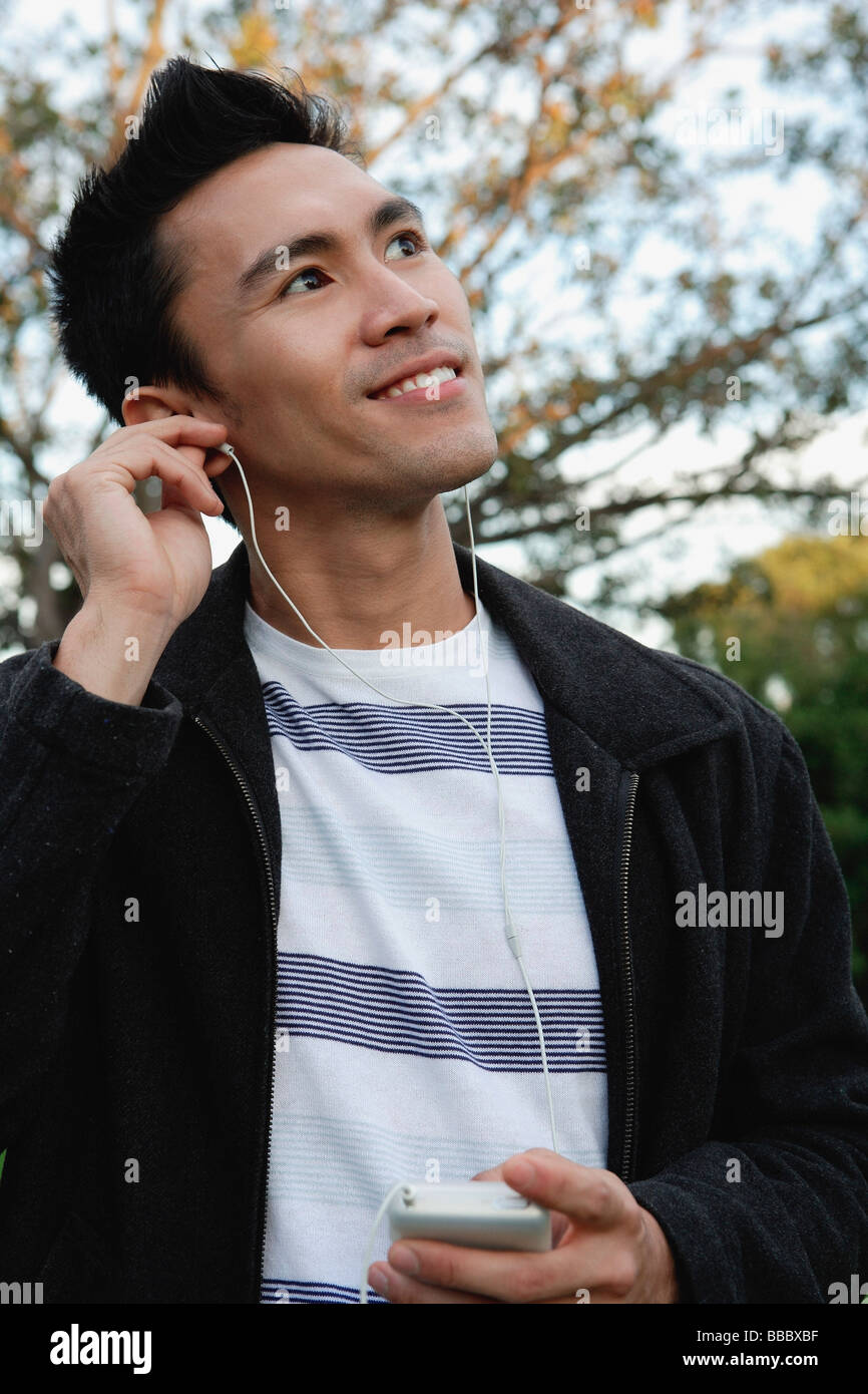Man outdoors, listening to MP3 player Stock Photo - Alamy