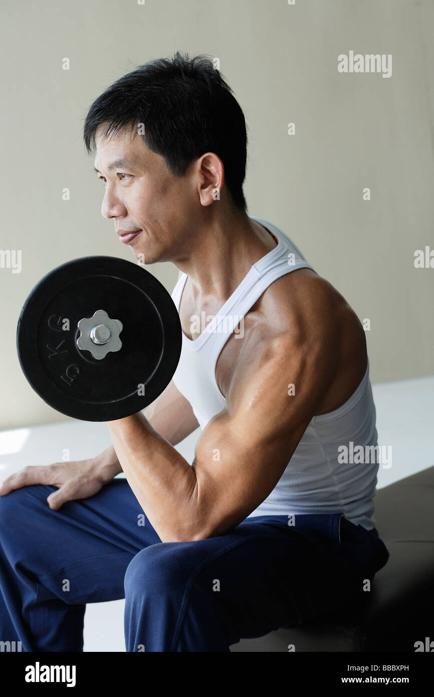 Profile of man lifting arm weights Stock Photo - Alamy