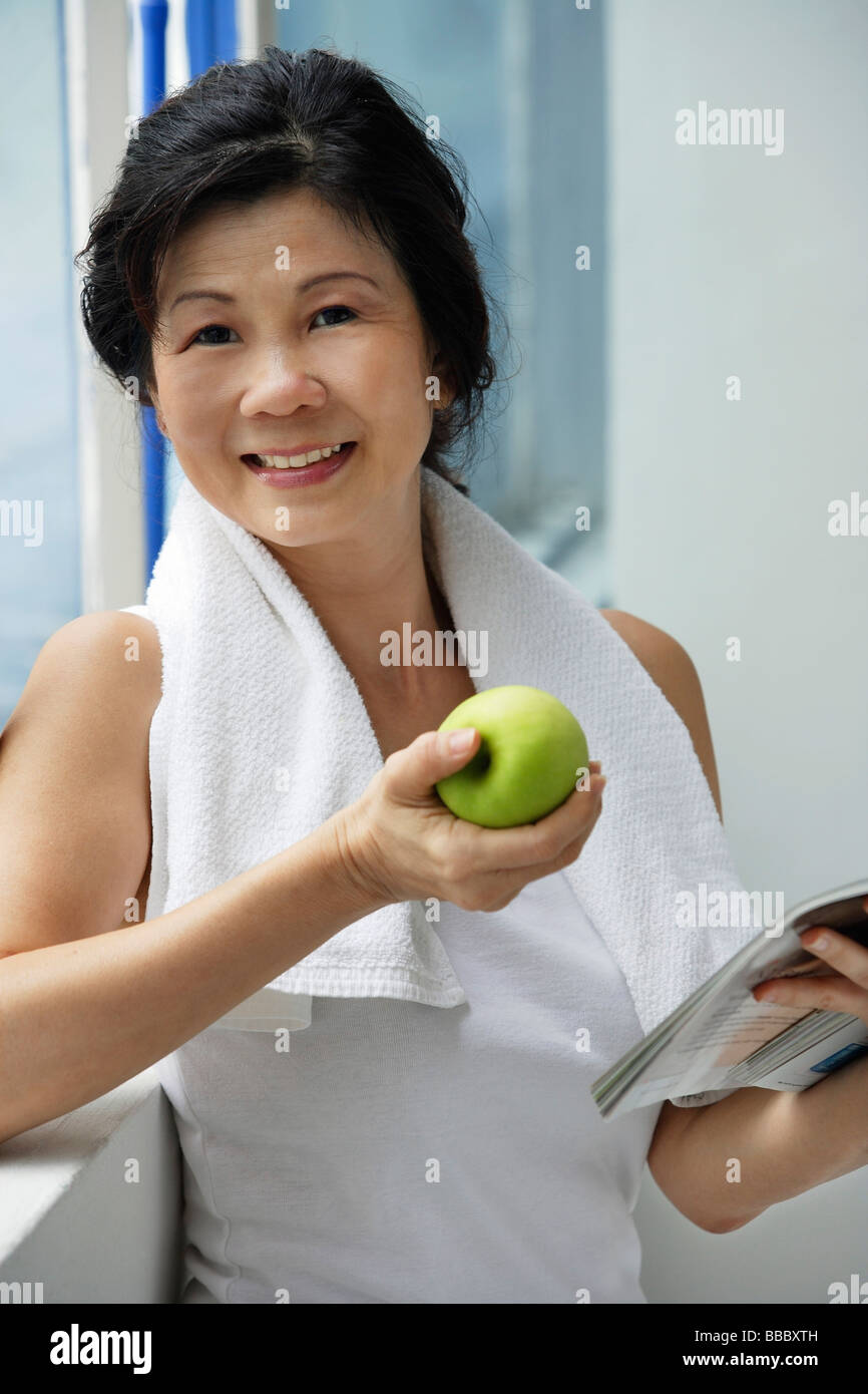 Woman eating apple after work out Stock Photo - Alamy