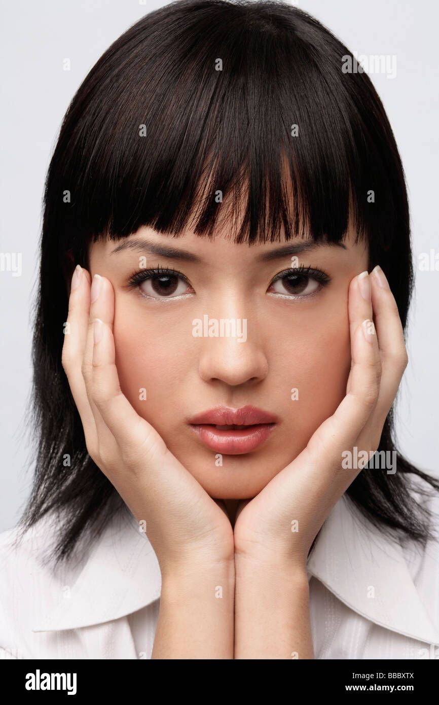 Portrait of woman with hands on face Stock Photo - Alamy