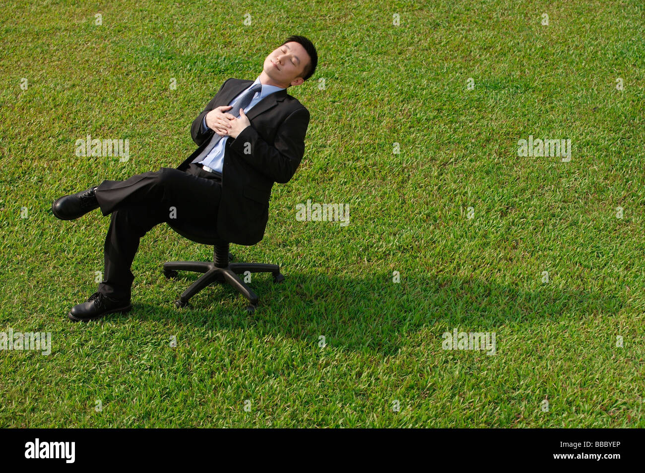 Businessman resting on an office chair Stock Photo - Alamy