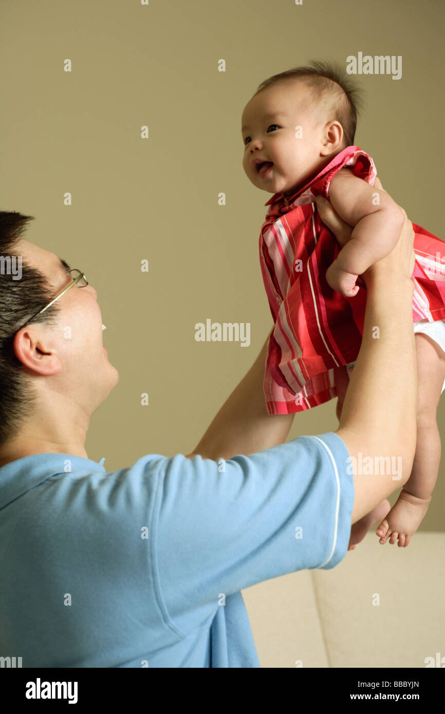 Father lifting baby girl up Stock Photo - Alamy