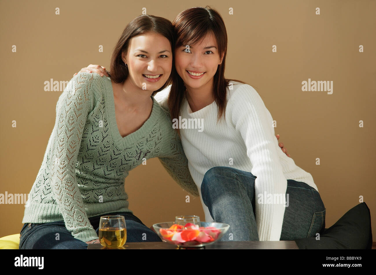 Friends with arms around each other smiling at camera Stock Photo - Alamy