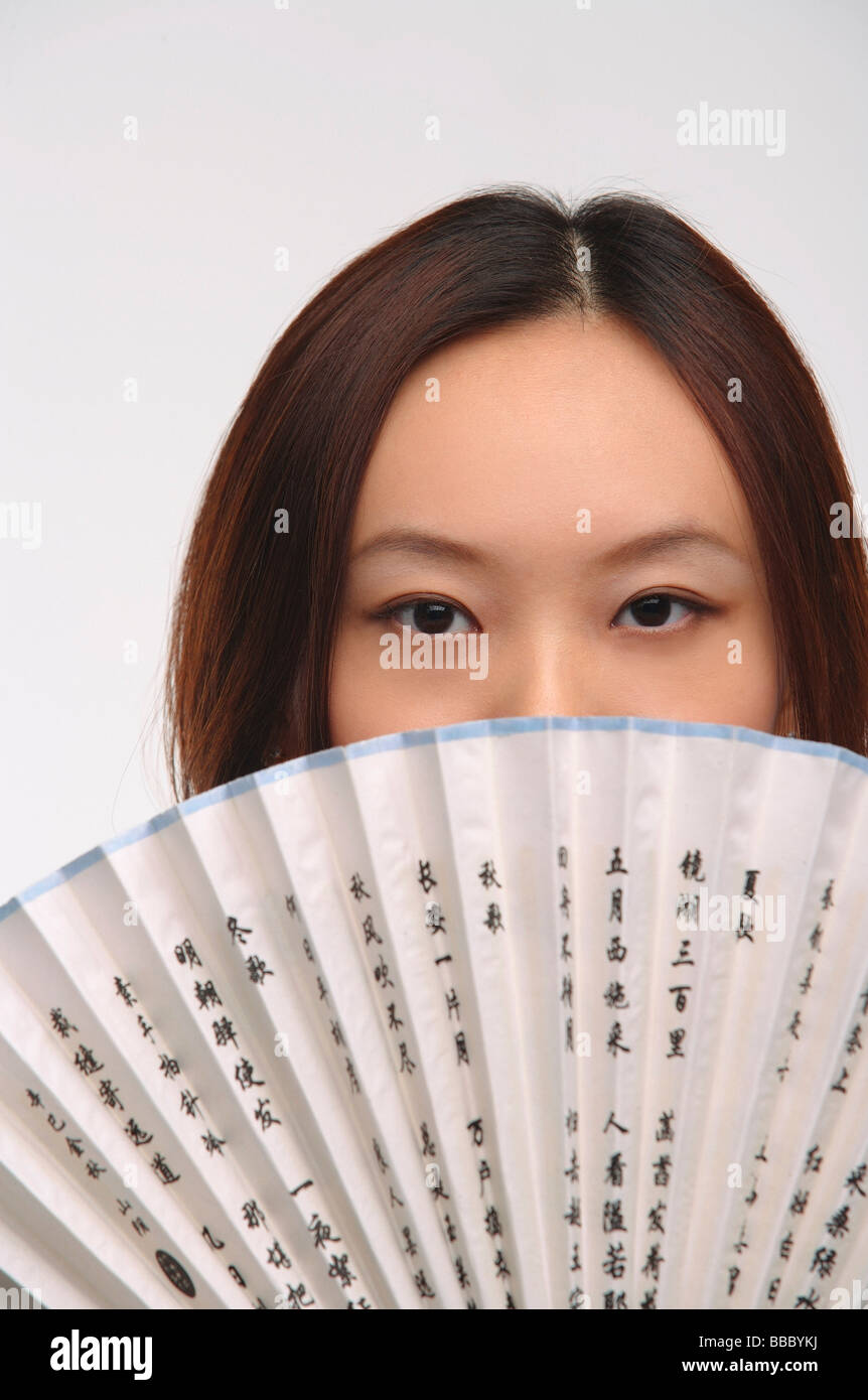 Young woman with fan looking at camera Stock Photo - Alamy