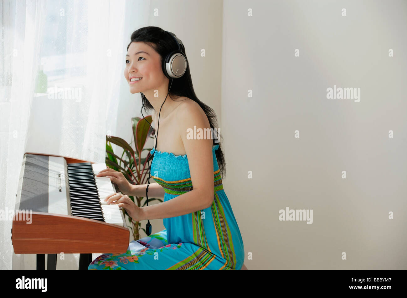 Young woman playing keyboard Stock Photo - Alamy