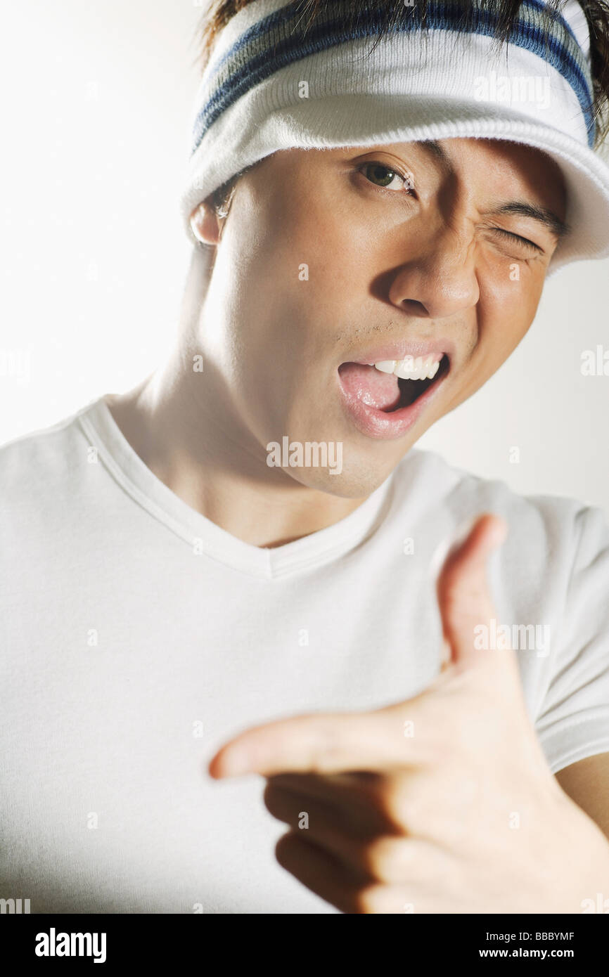 Young man looking at camera, winking and making hand sign Stock Photo ...