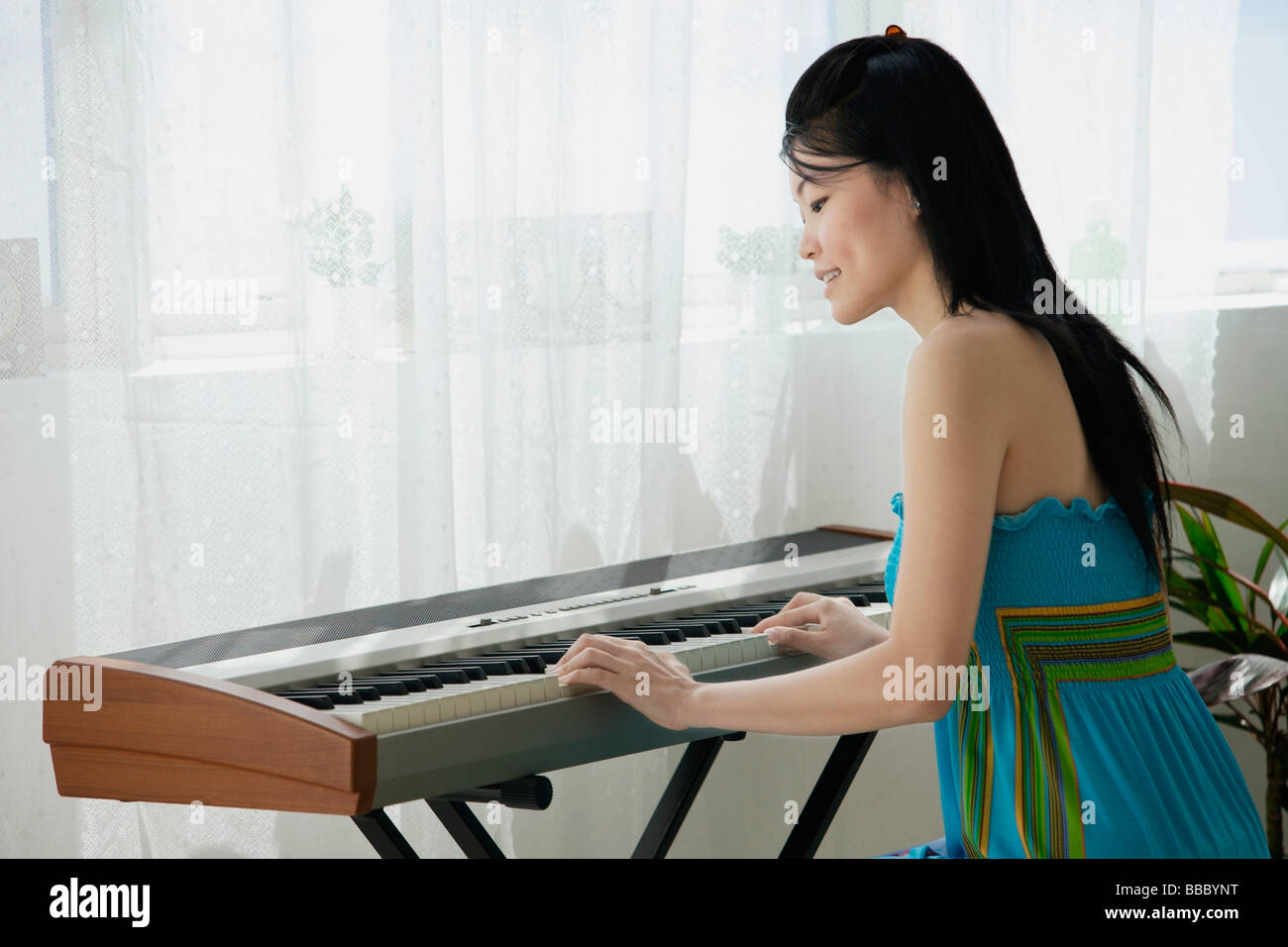 Young woman playing keyboard Stock Photo - Alamy