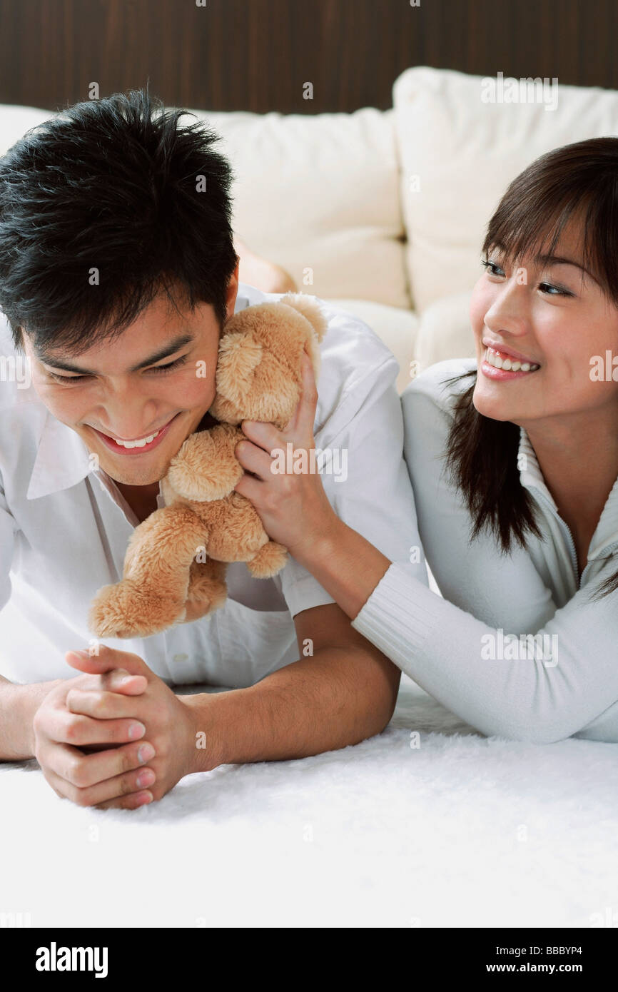 Young couple laughing while hugging and lying on the floor Stock Photo ...