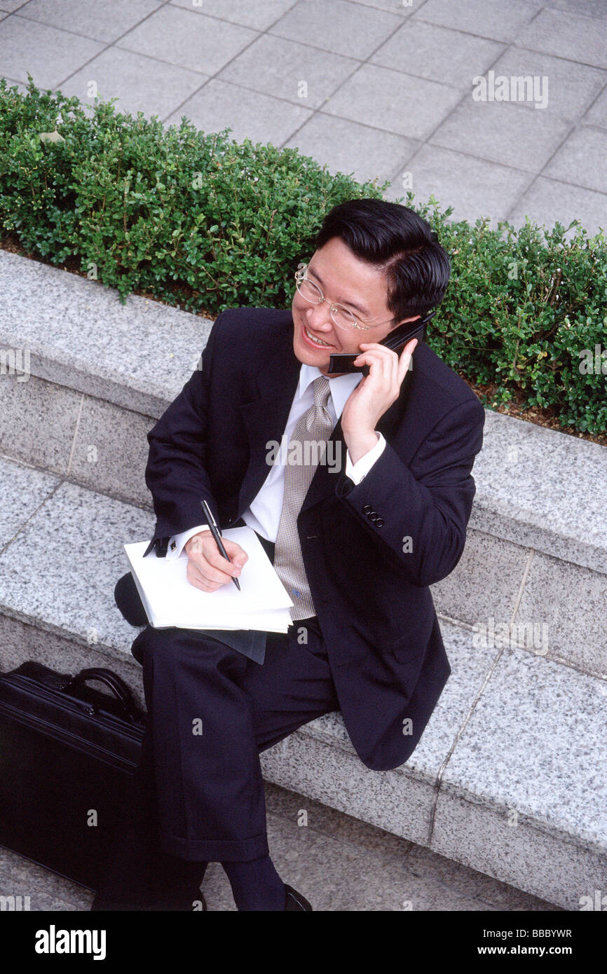 Man in business suit, using mobile phone Stock Photo - Alamy