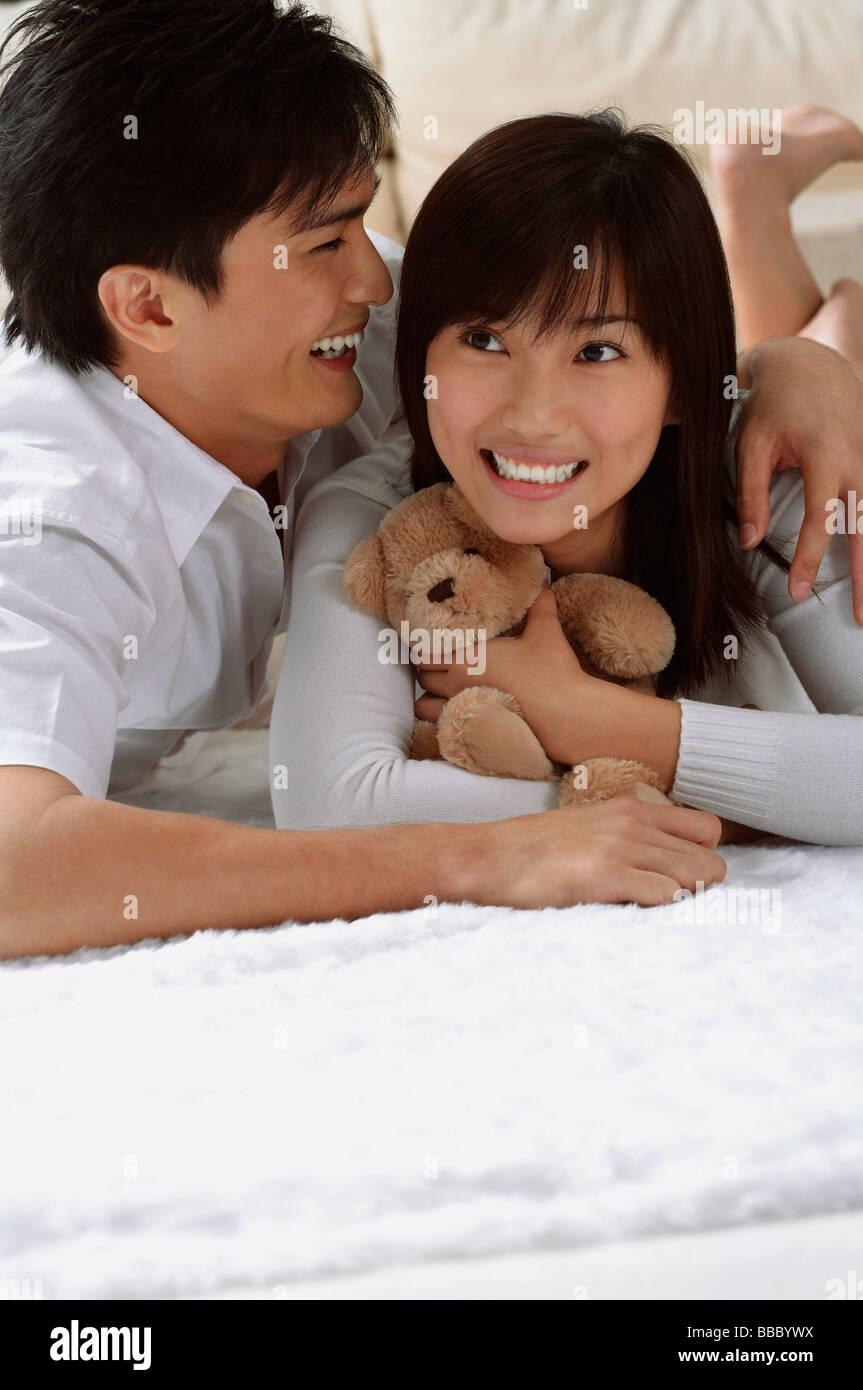 Young couple laughing while hugging and lying on the floor Stock Photo ...