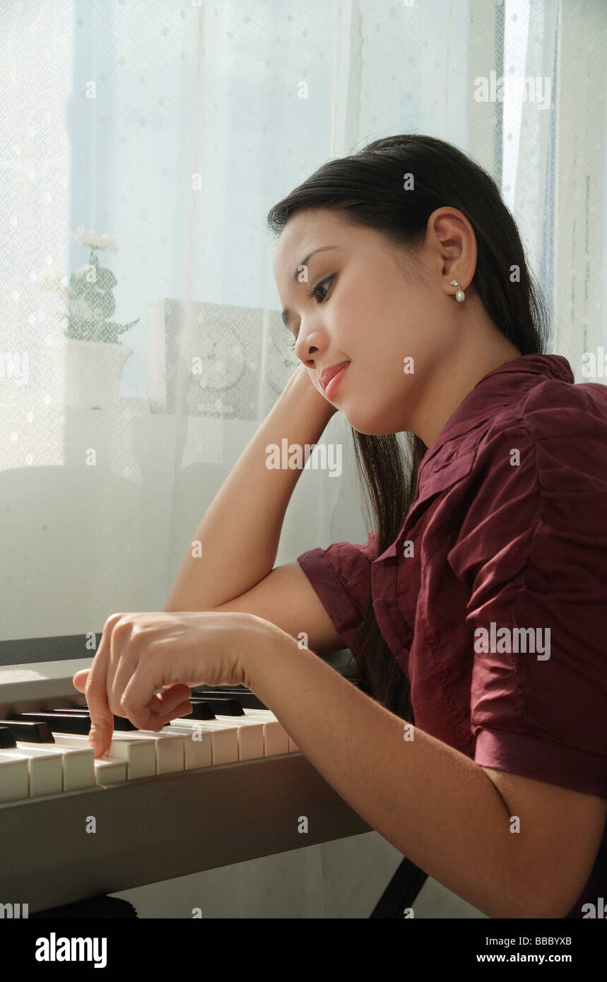 Young woman playing keyboard Stock Photo - Alamy