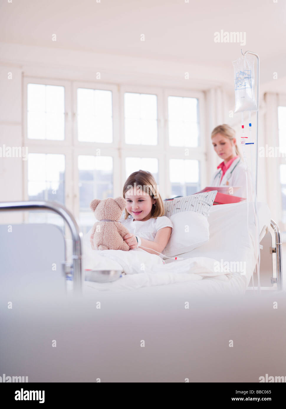 female medic and girl in bed with teddy Stock Photo - Alamy